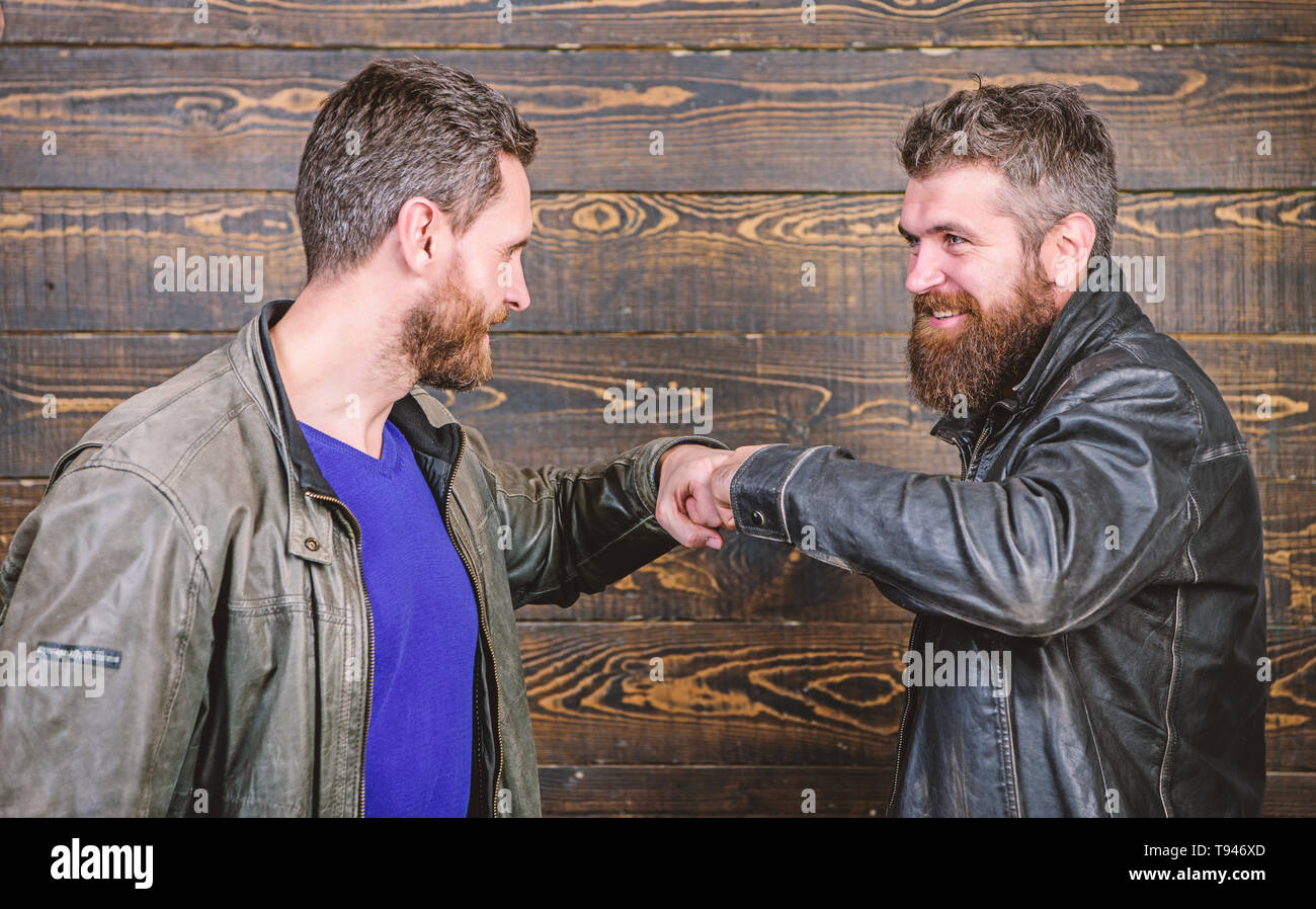 Brutal bearded men wear leather jackets shaking hands. Strong handshake ...