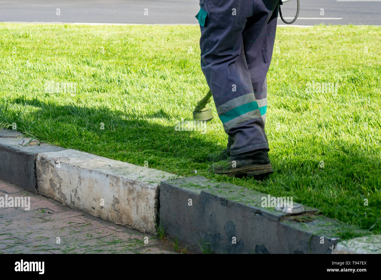 The gardener cutting grass by lawn mower, lawn care Stock Photo - Alamy