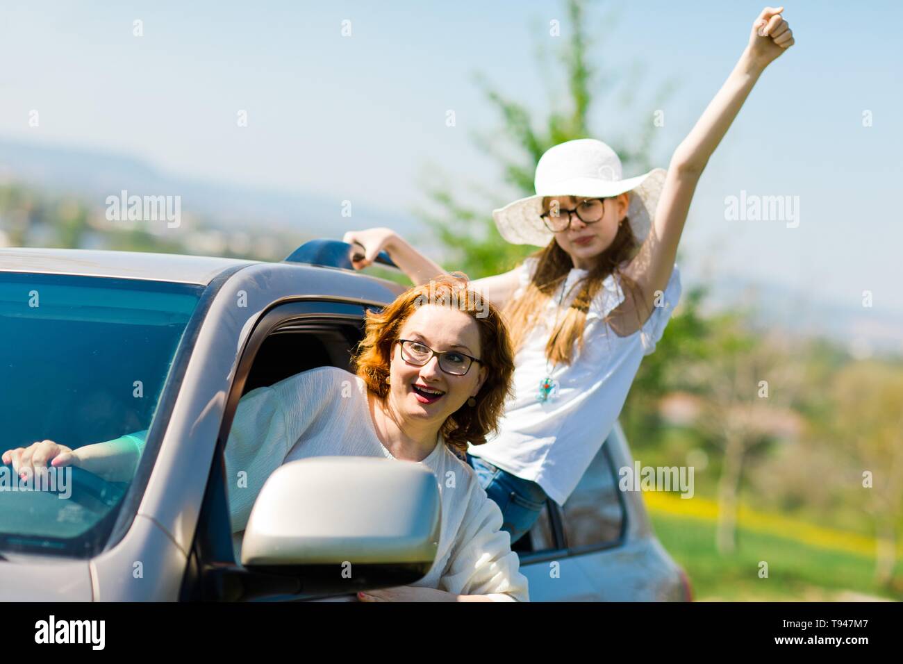 Rioters behind the wheel, female hooligans in the car showing gestures ...