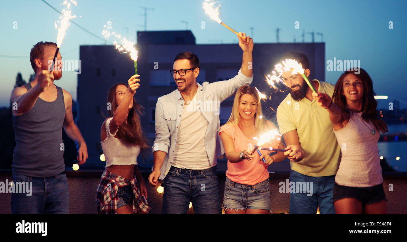 Happy friends lighting sparklers and enjoying freedom Stock Photo - Alamy