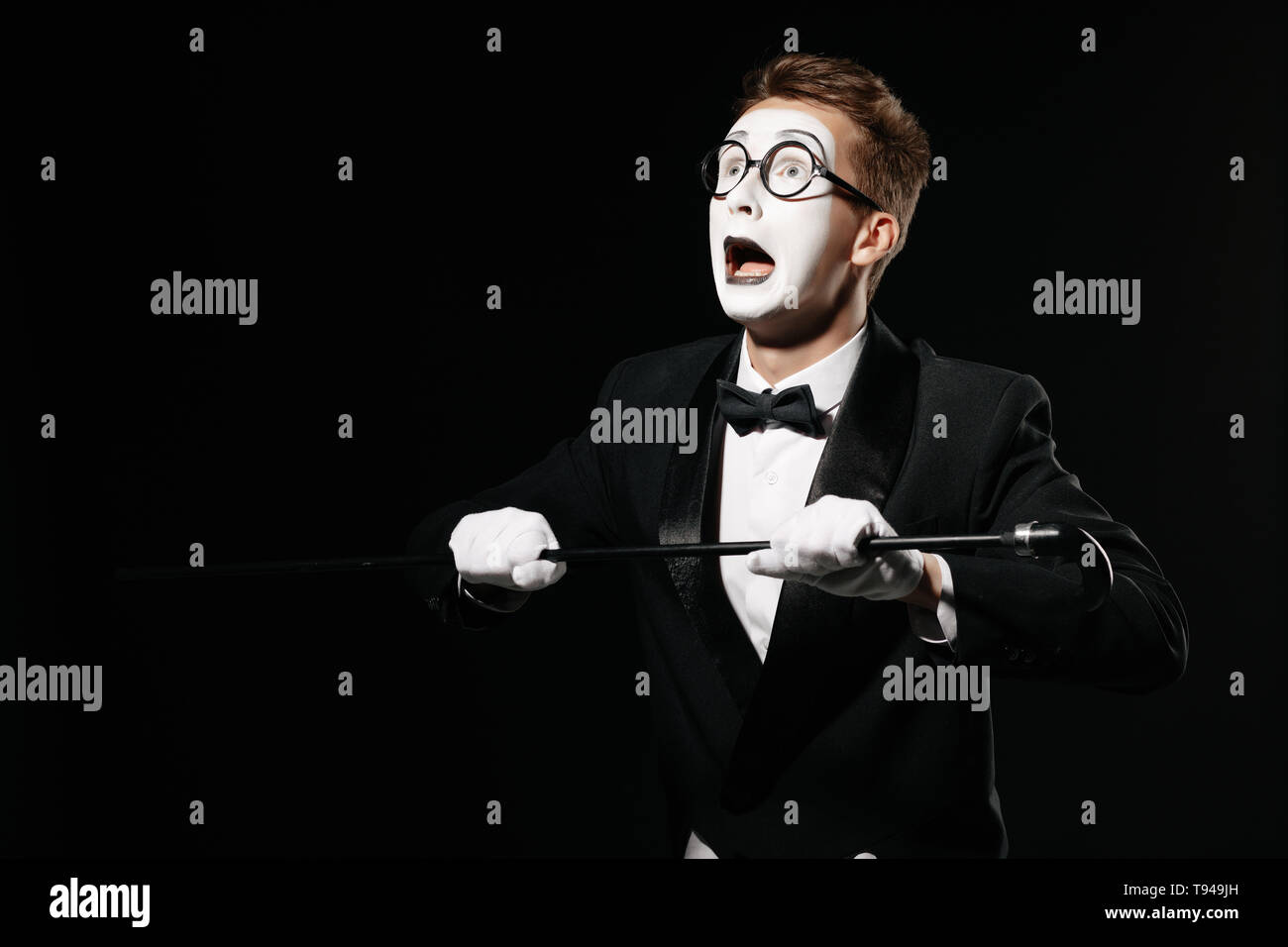 surprised mime man in tuxedo and glasses posing with walking stick on ...