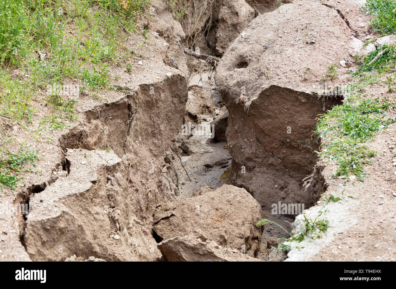 Erosion, destruction of soil on a mountain path after heavy rain among ...
