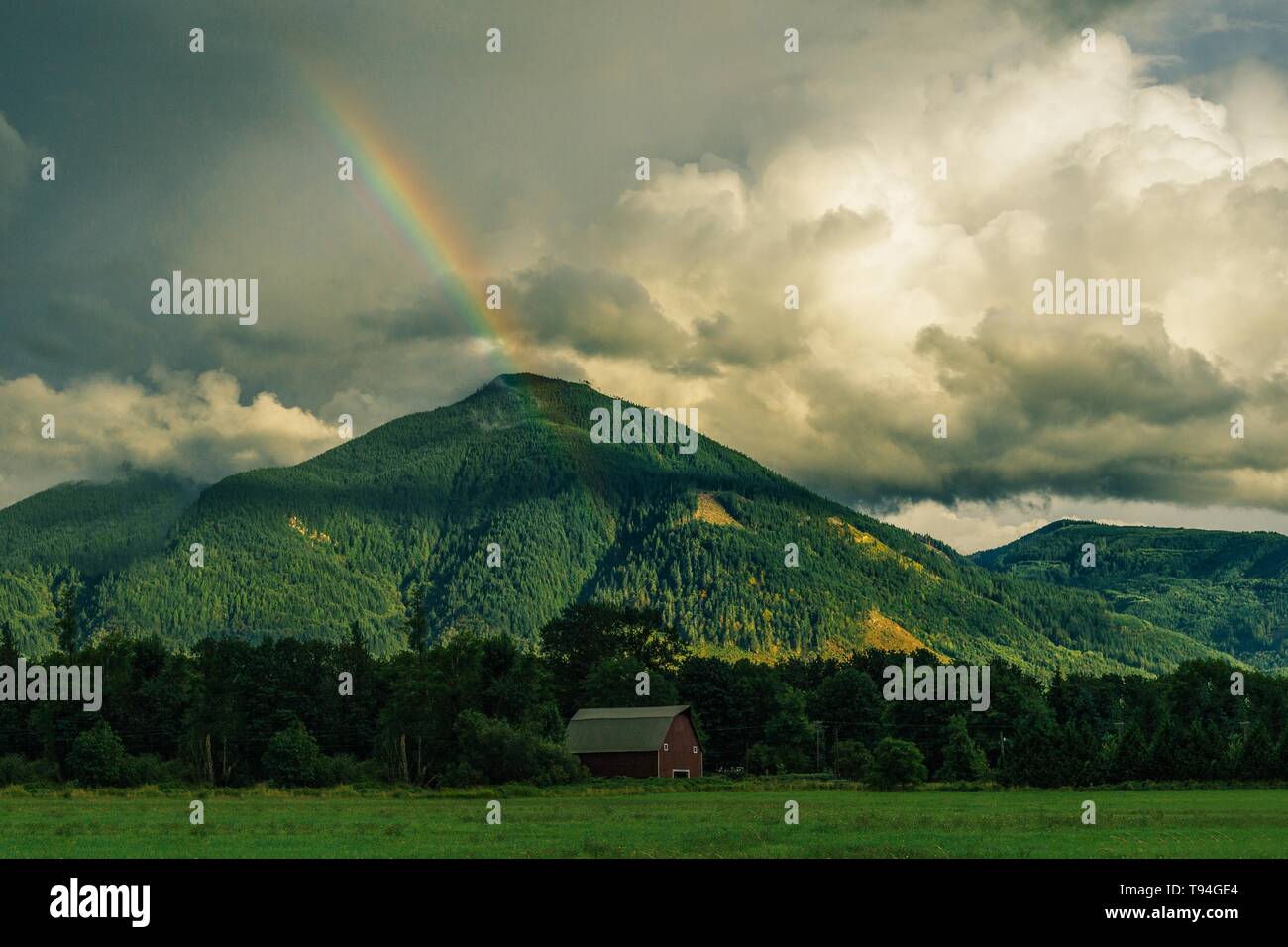 Beautiful scenery with high hills amazing clouds and a rainbow behind ...