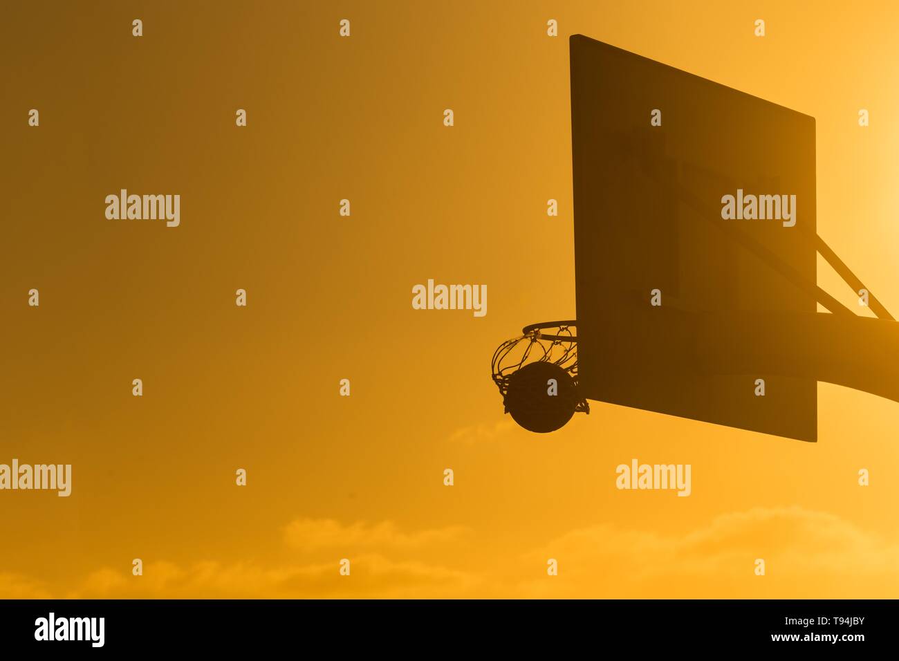 Basketball hoop with sun shining from an angle Stock Photo - Alamy