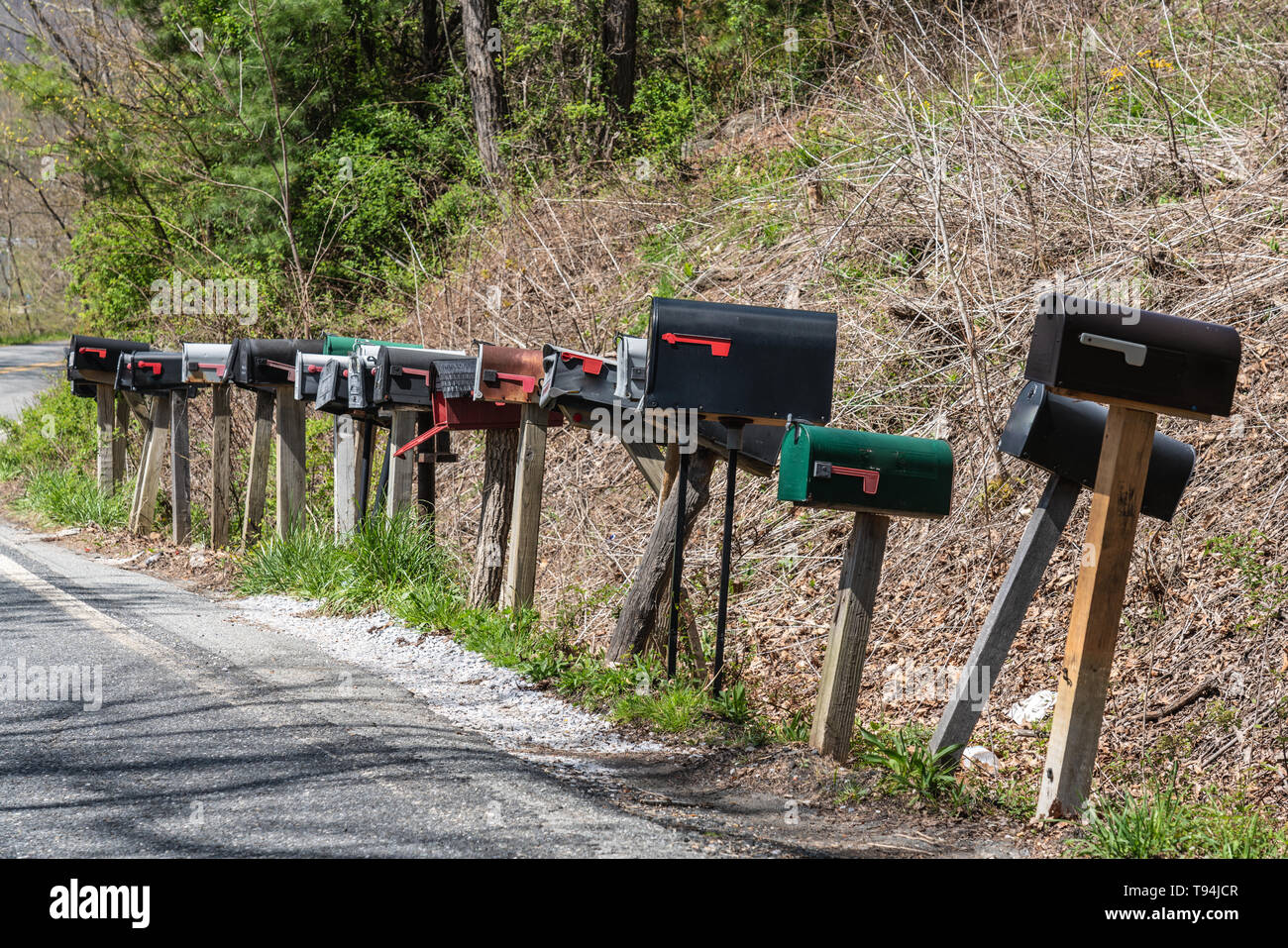 US mailboxes on wooden posts in a row along a rural roadway Stock Photo ...