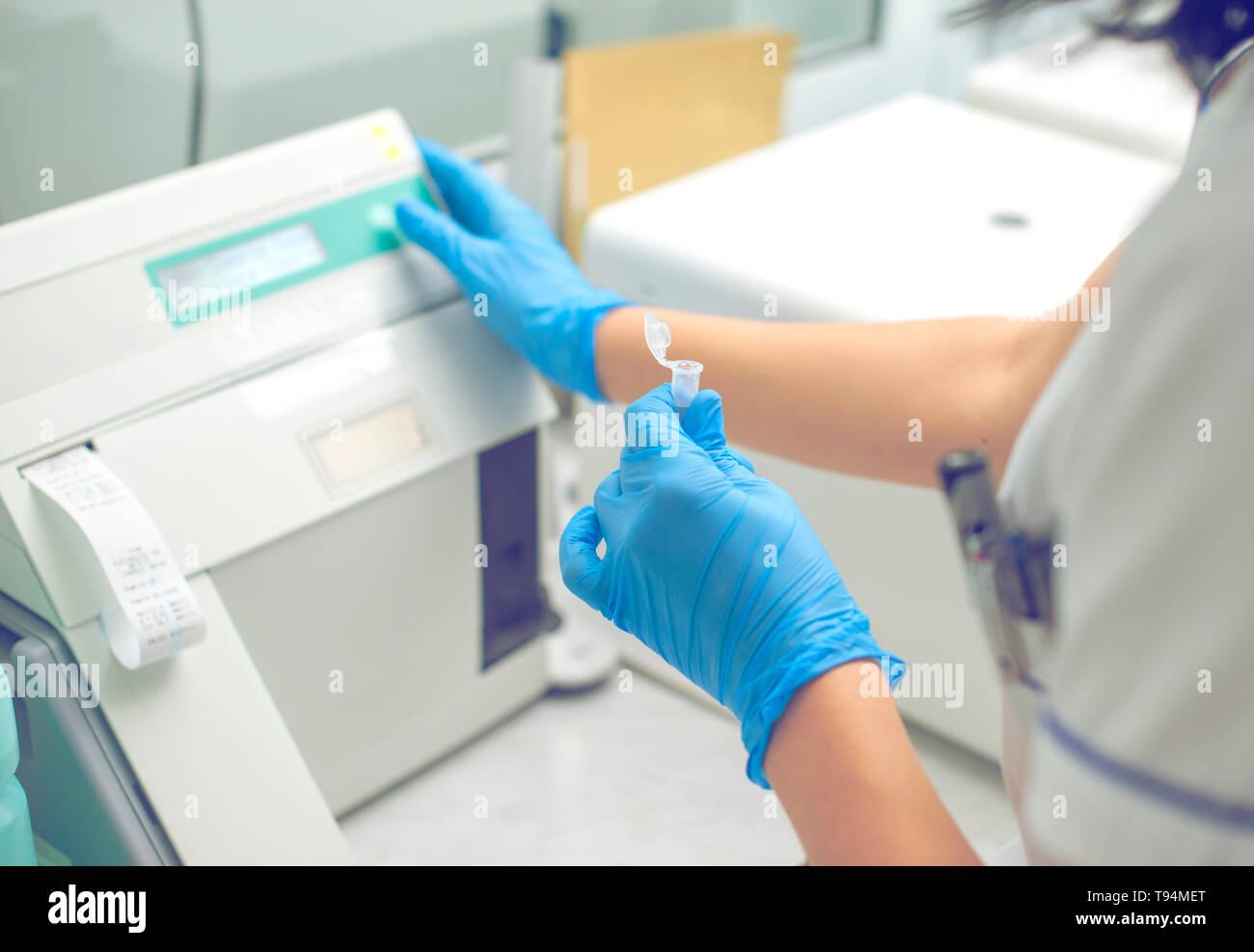 Woman working in a laboratory on a modern machine for blood testing ...