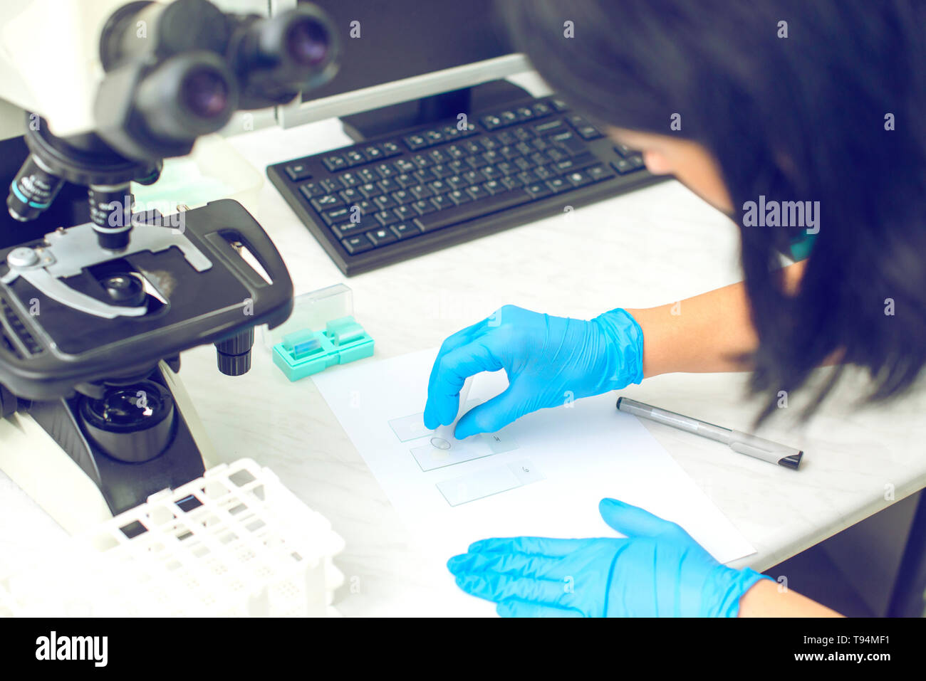 Woman working in a laboratory on a modern machine for blood testing ...
