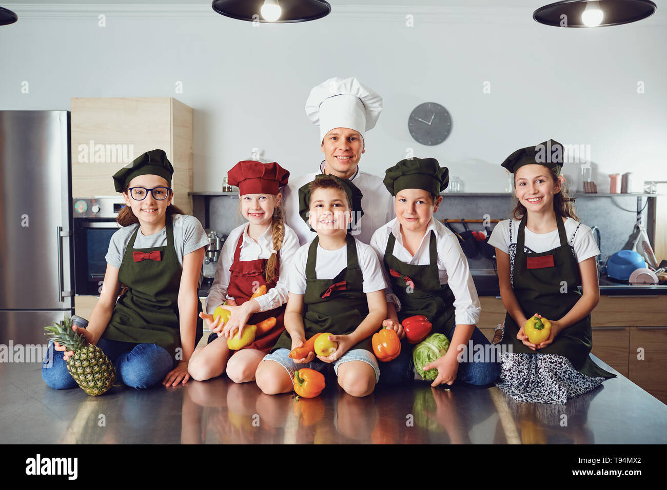 Chef and kids with vegetables in stylish kitchen Stock Photo - Alamy