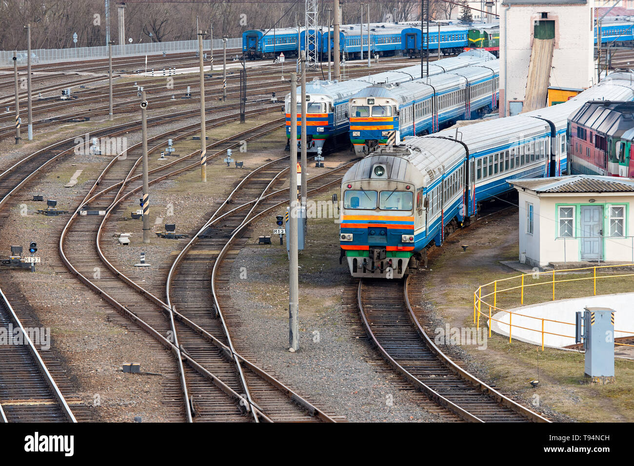 Diesel locomotives and carriages stand in depot with lots of rail forks ...