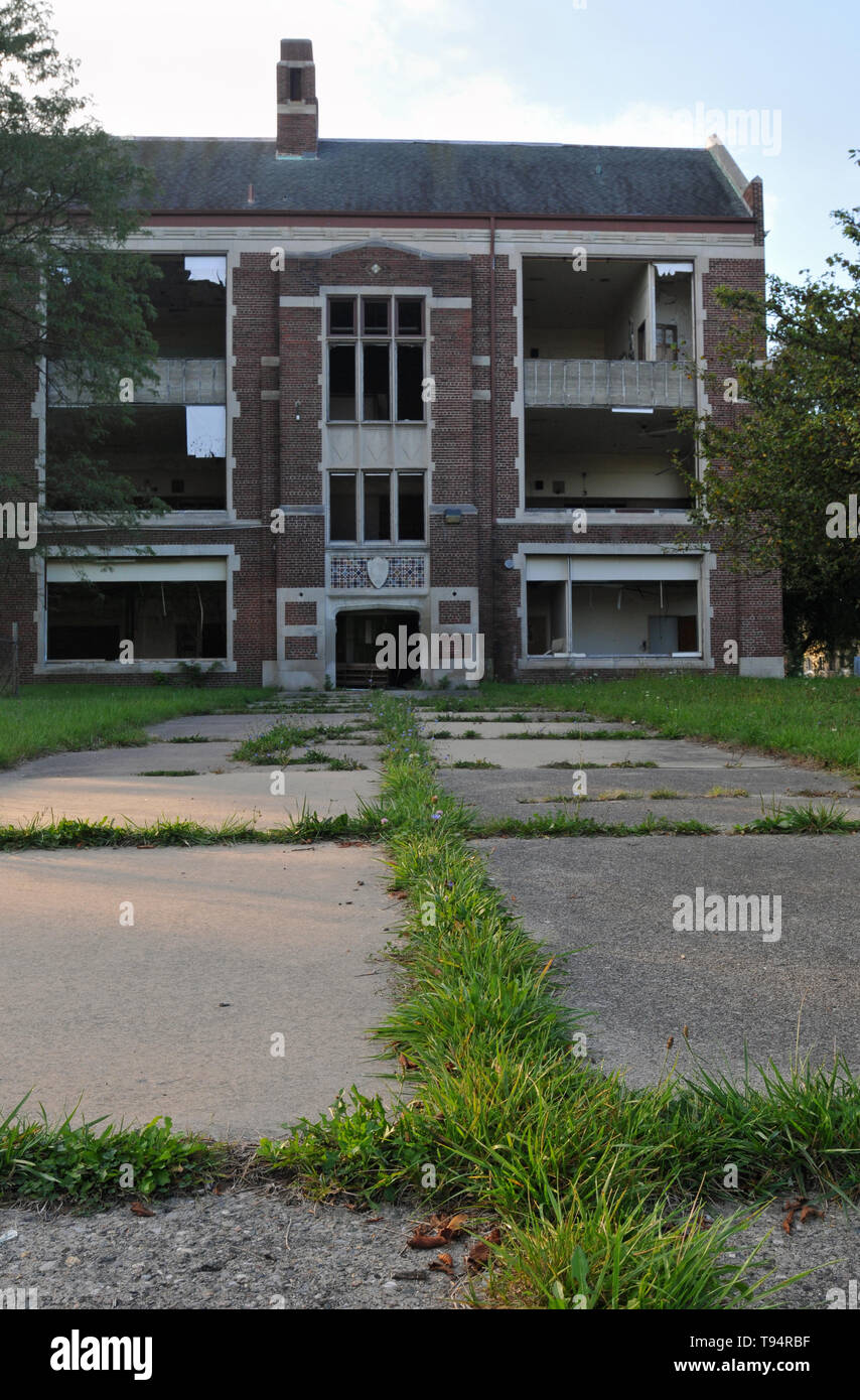 An overgrown walkway leads to an abandoned public school in Detroit ...