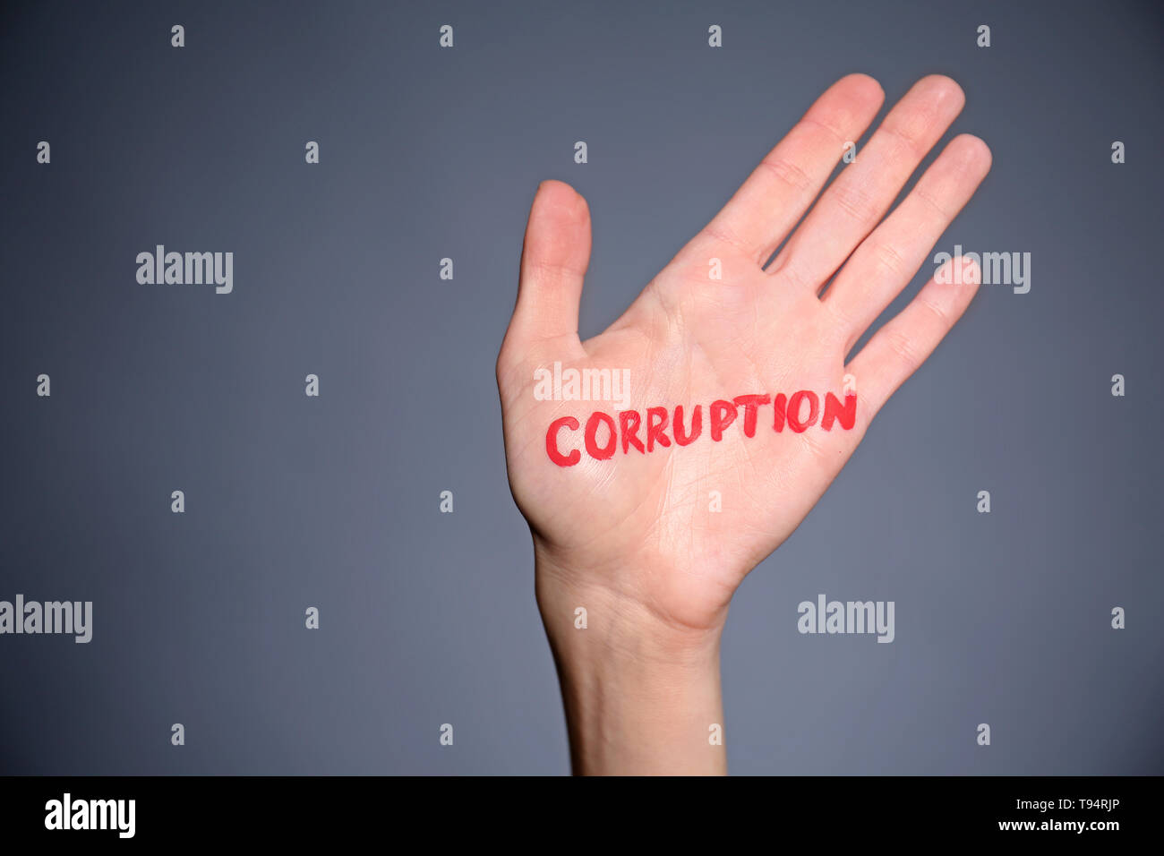 Female palm with written word CORRUPTION on grey background Stock Photo ...