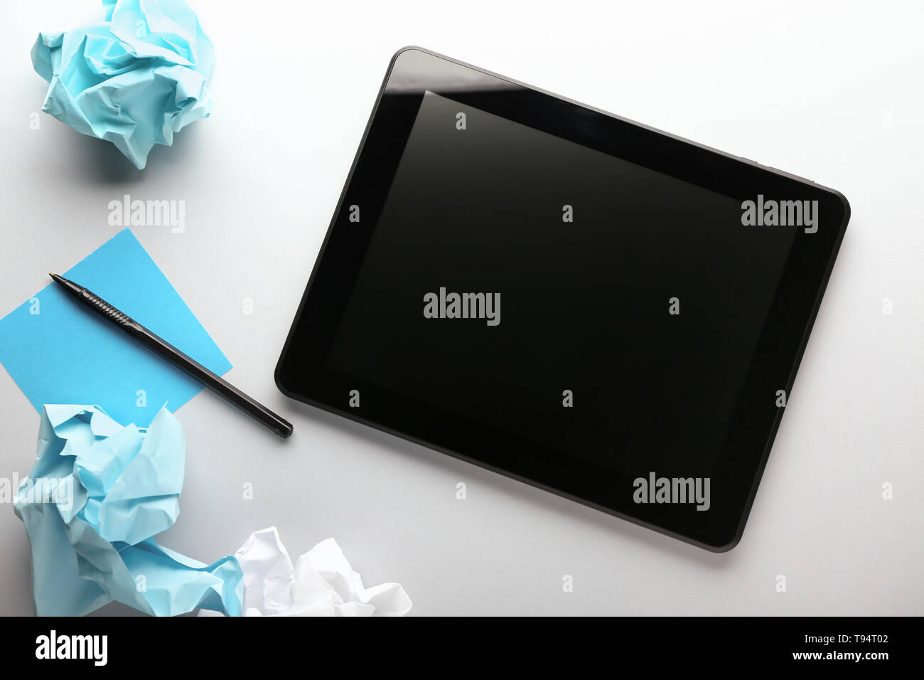 Tablet computer and crumpled paper on white background. Mistake concept ...