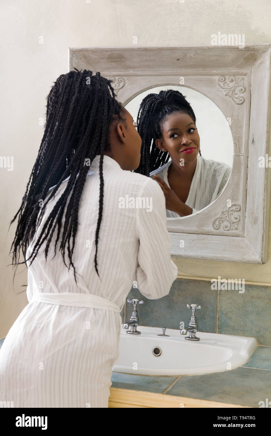 Pretty young african american woman doing her morning routine in front ...