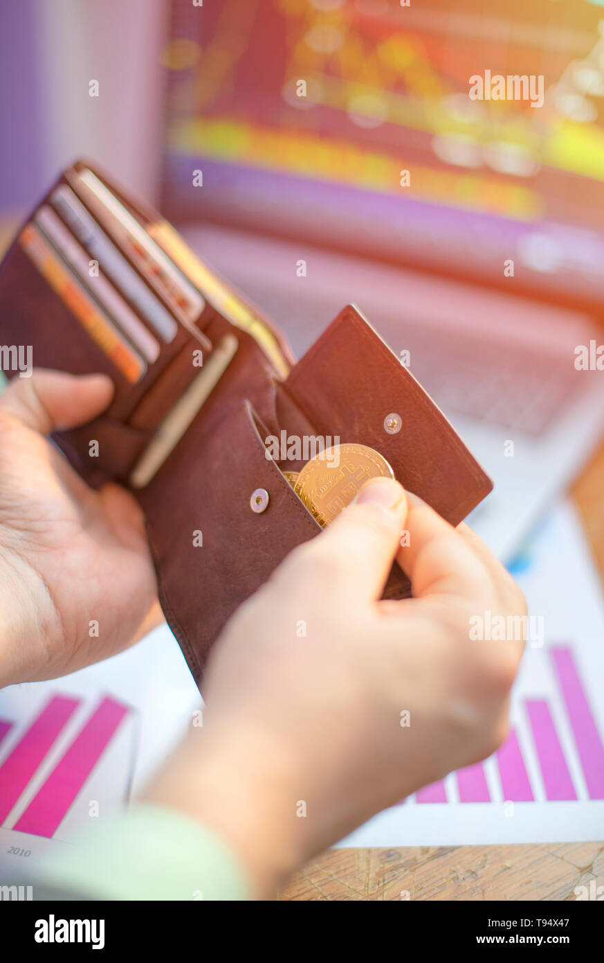 Hand putting virtual golden bitcoins into wallet Stock Photo - Alamy