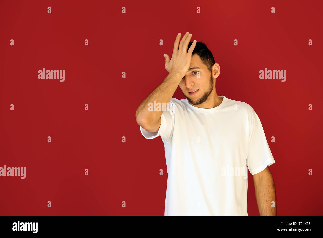 Emotional young man after making mistake on color background Stock ...