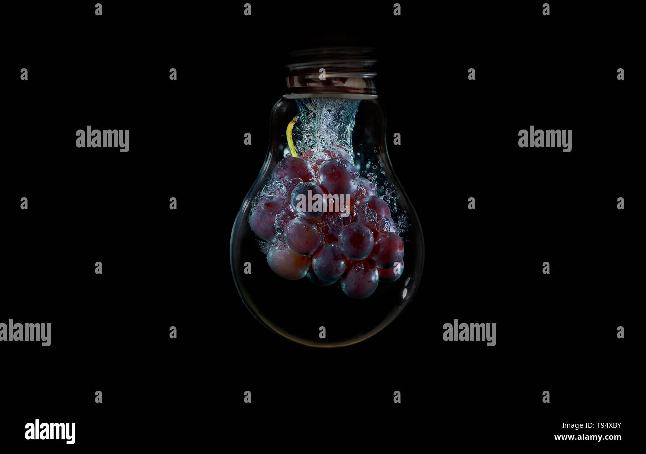 Grape inside a light bulb with water flowing Stock Photo - Alamy