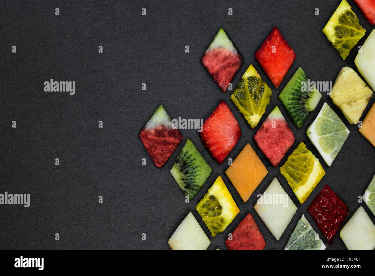 Abstract composition of diamond shape various fruit puzzle on black ...