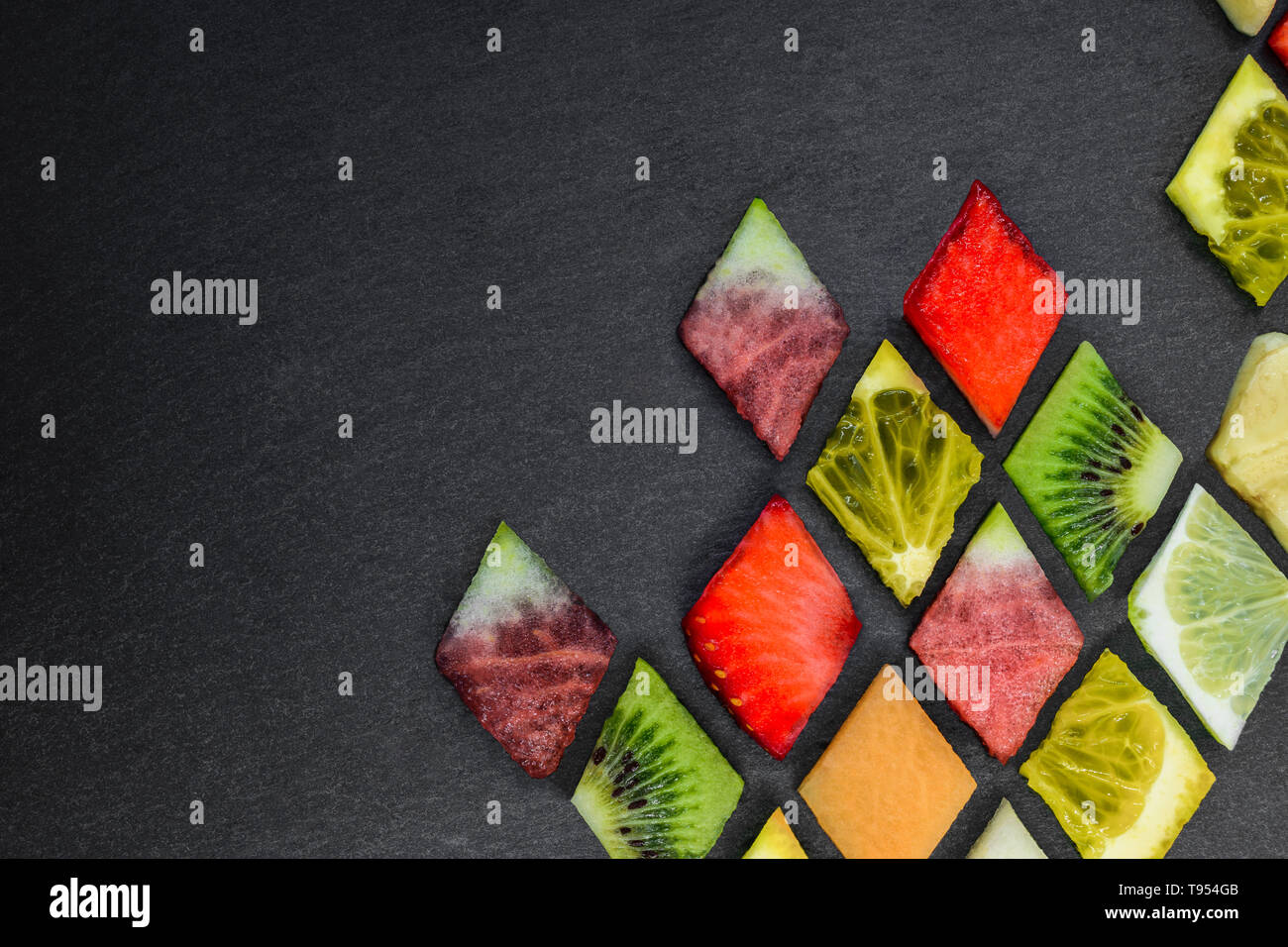 Abstract composition of diamond shape various fruit puzzle on black ...