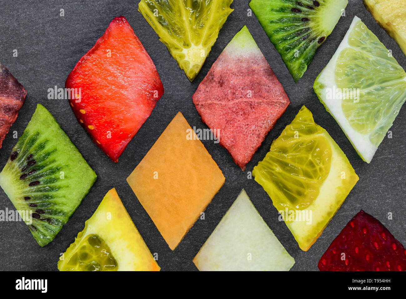 Abstract composition of diamond shape various fruit puzzle on black ...