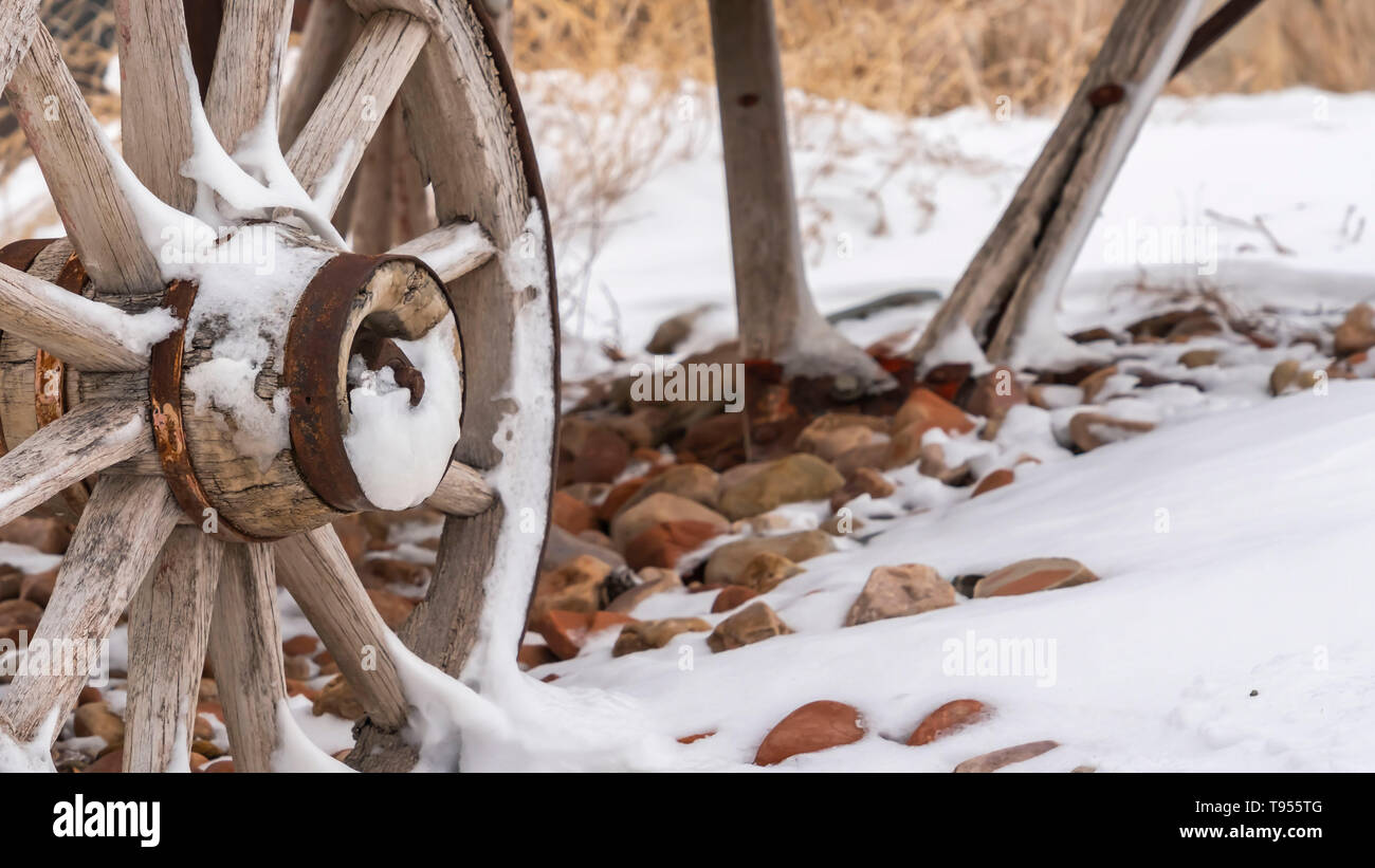 Panorama An old wooden wagon with rusty wheels dusted with snow in ...