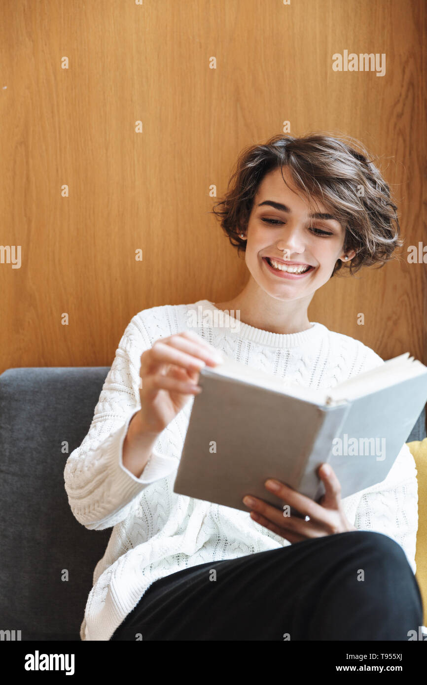 Happy young student girl studying at the library, reading a book Stock ...
