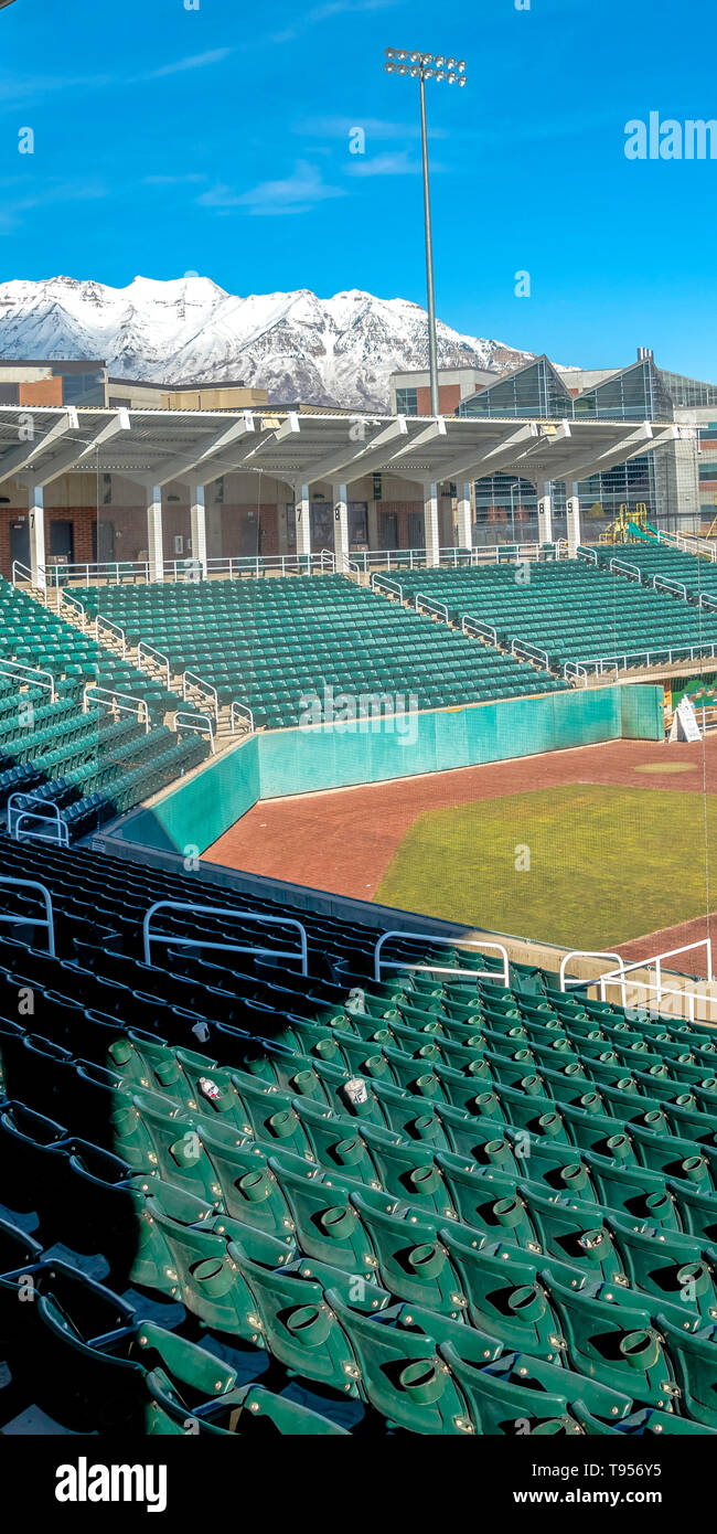 Vertical Baseball field with green tiered seating against mountain and ...