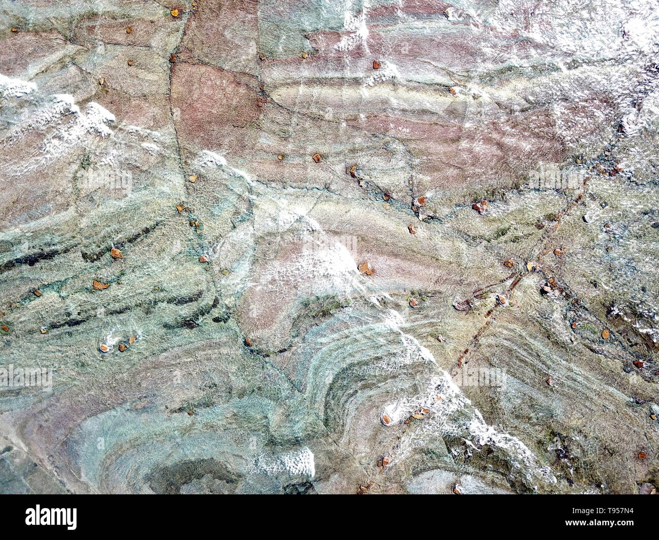 Aerial top view of rocky beach at low tide. Top view of sea water ...