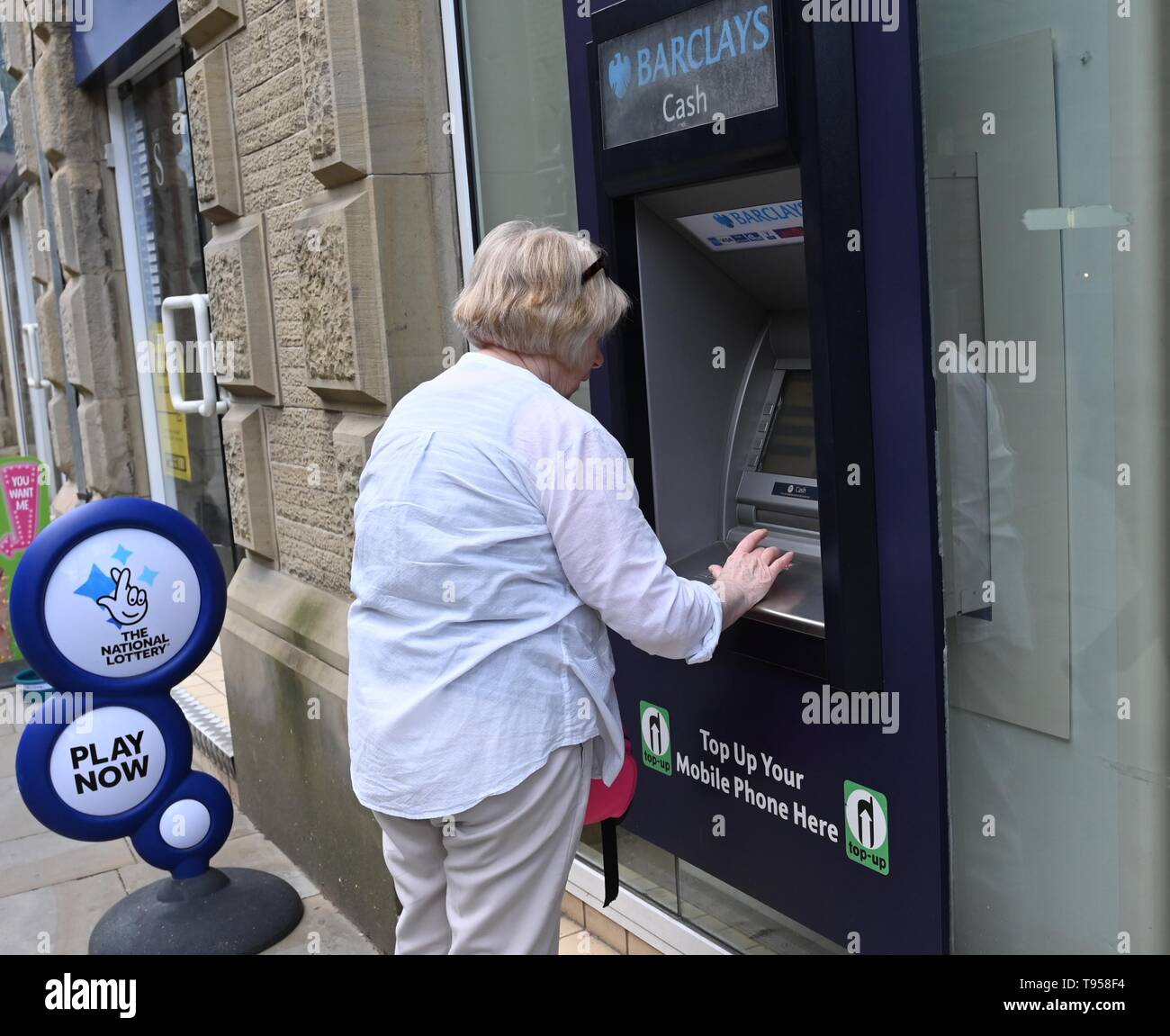 A woman at a service till in Buxton, Derbyshire Stock Photo - Alamy