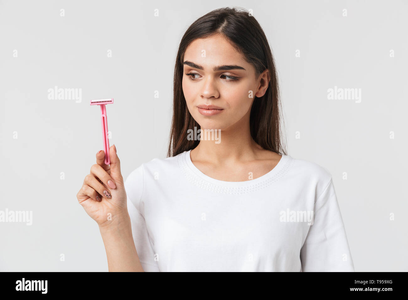 Portrait of a beautiful young woman casualy dressed standing isolated ...