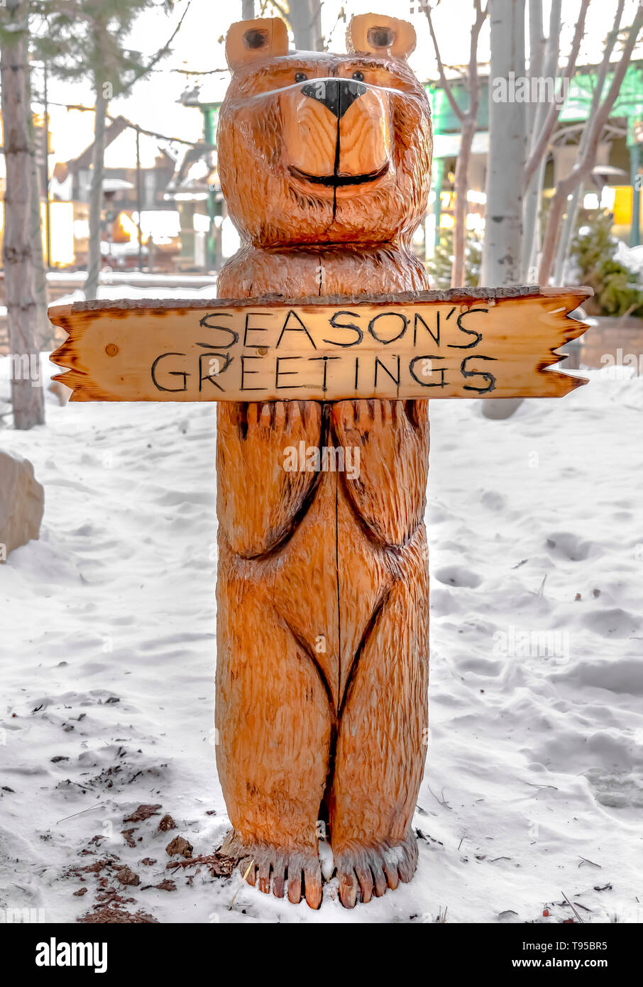 Bear wood sculpture on a landscape covered with powdery white snow in ...
