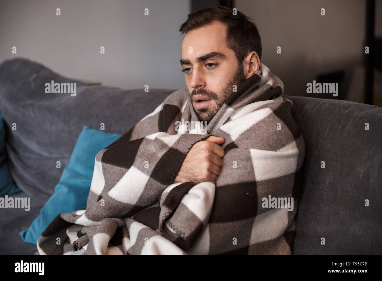 Sick male wrapped in blanket hi-res stock photography and images - Alamy