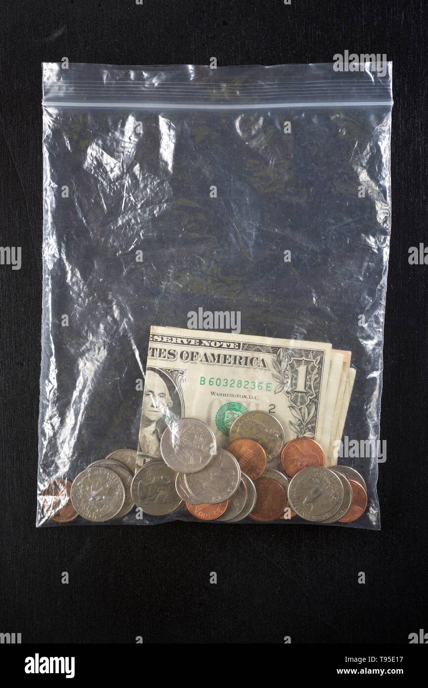 Dollar bills and coins in a plastic bag Stock Photo - Alamy