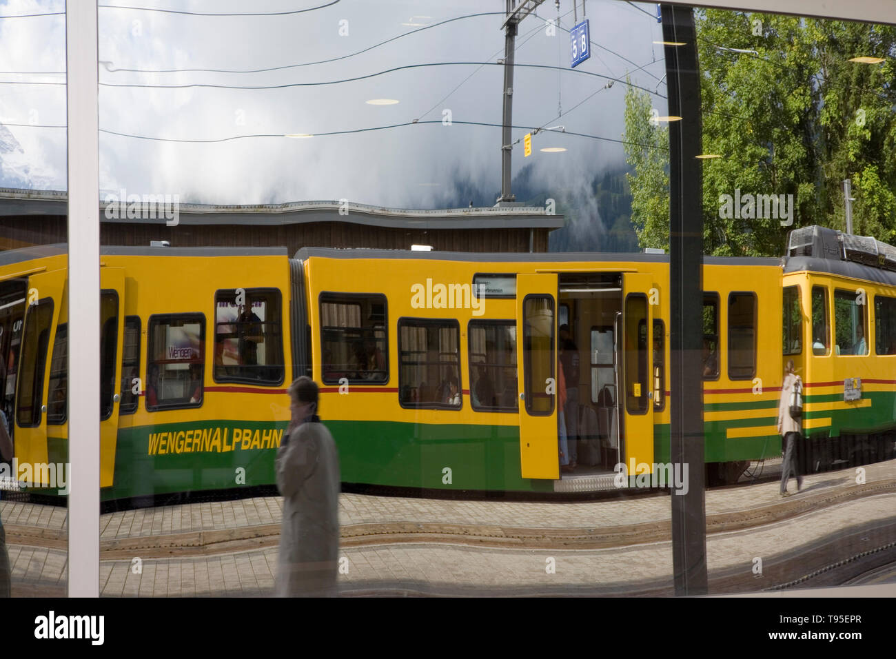 Wengen station: a Wengernalpbahn train reflected in mirrored glass ...