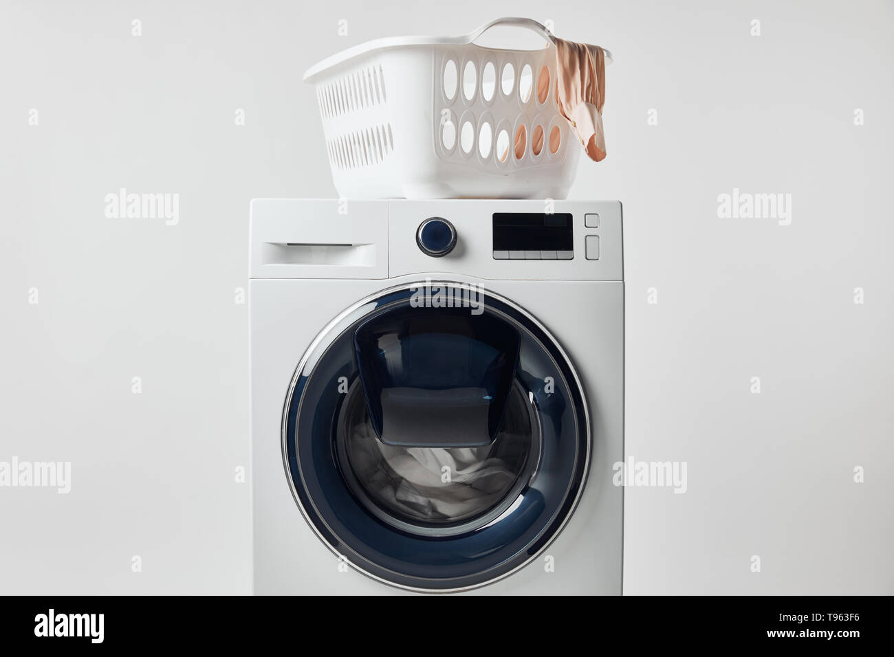 Washing machine with laundry basket isolated on grey Stock Photo - Alamy