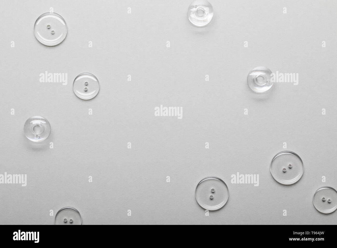 top view of transparent clothing buttons isolated on grey with copy ...