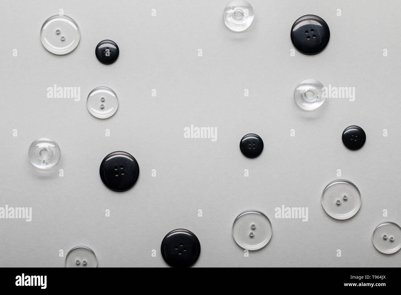top view of transparent and black clothing buttons isolated on grey ...