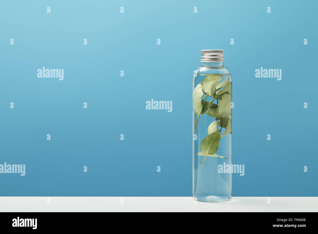 organic cosmetic product with green leaves in transparent bottle ...