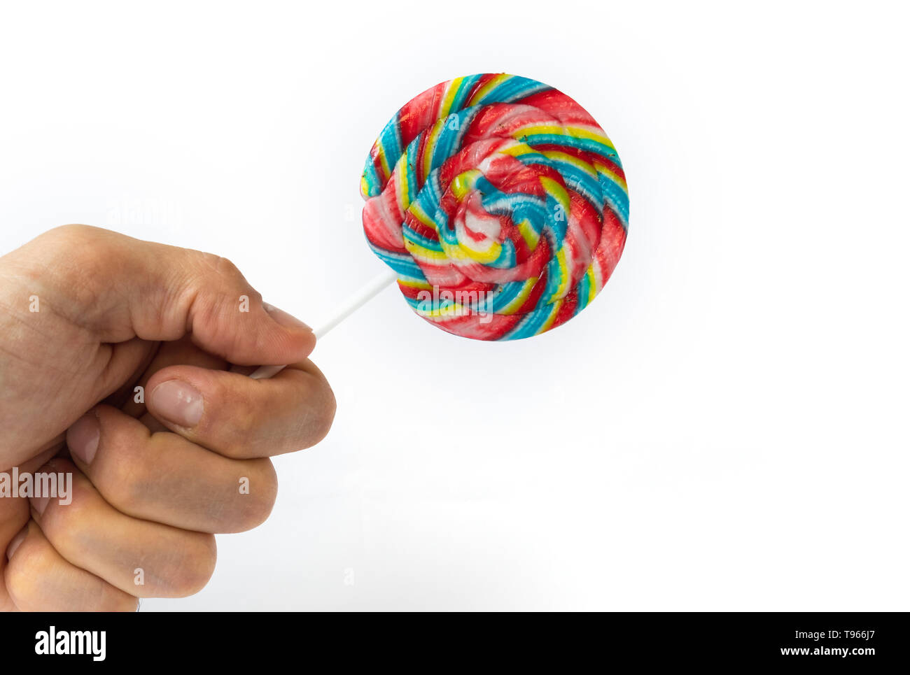 Hand holding a lollipop against white background Stock Photo - Alamy