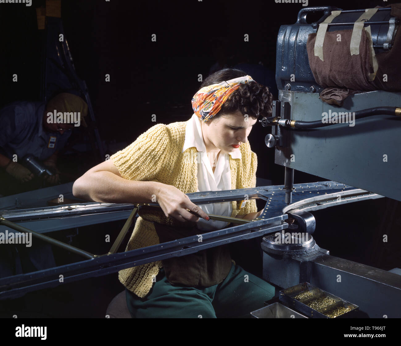A girl riveting machine operator at the Douglas Aircraft Company plant ...