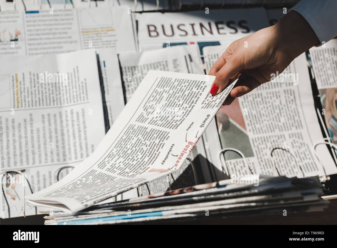 partial view of woman taking daily print newspaper from stand Stock ...