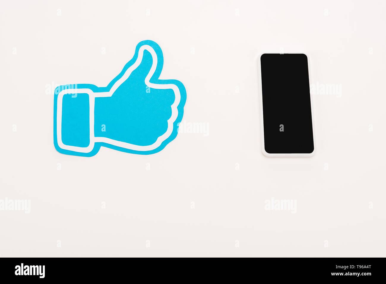 blue thumb up sign near laptop with blank screen isolated on white ...