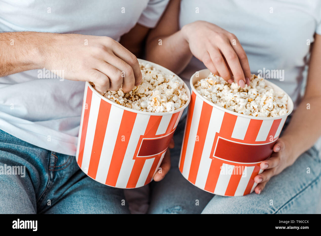 partial view of couple in jeans with popcorn Stock Photo - Alamy