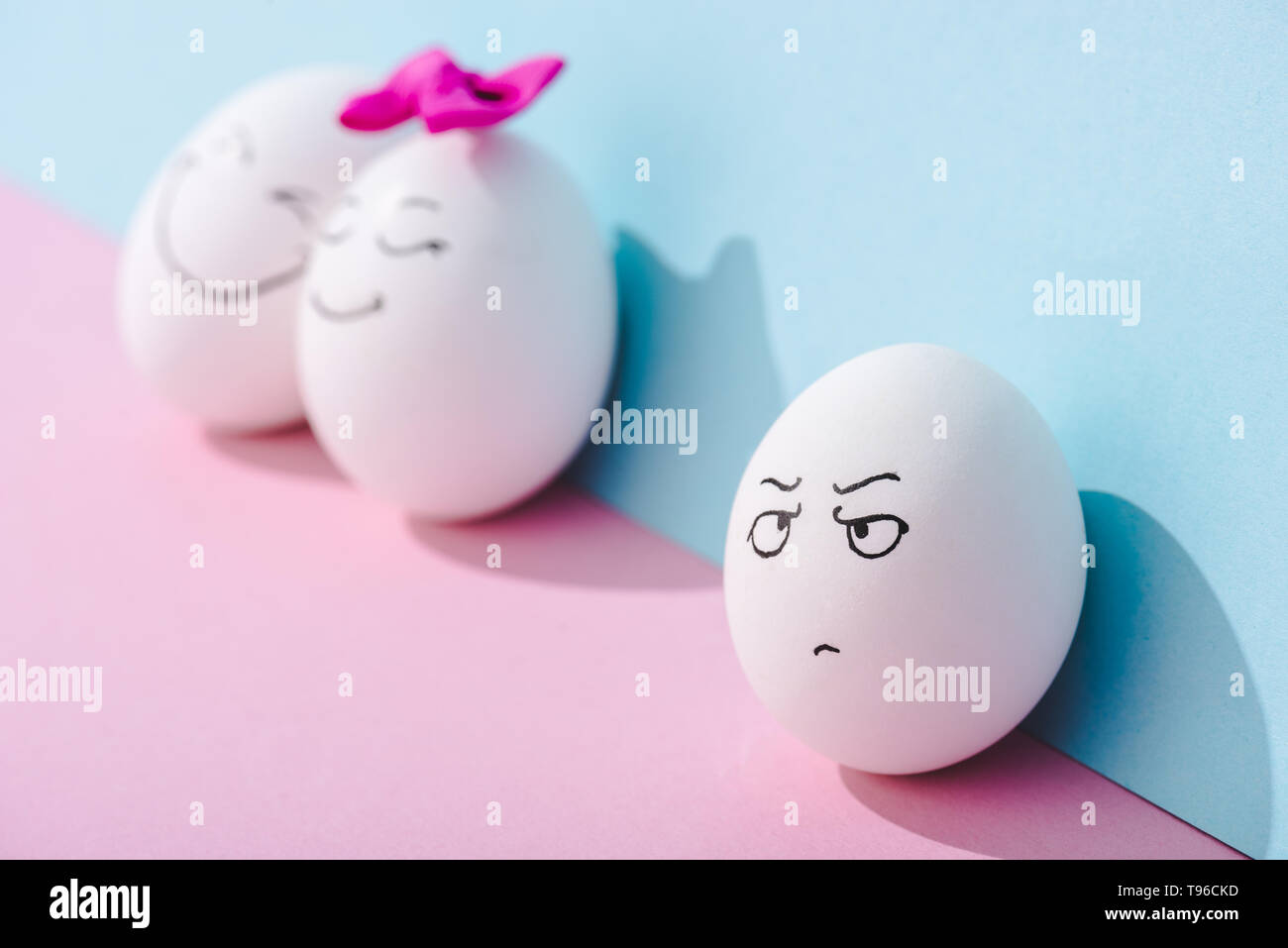 selective focus of egg with angry face expression near eggs with happy ...