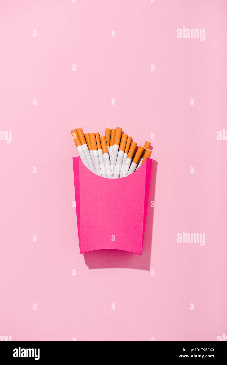 top view of cigarettes packed in paper box on pink with copy space ...