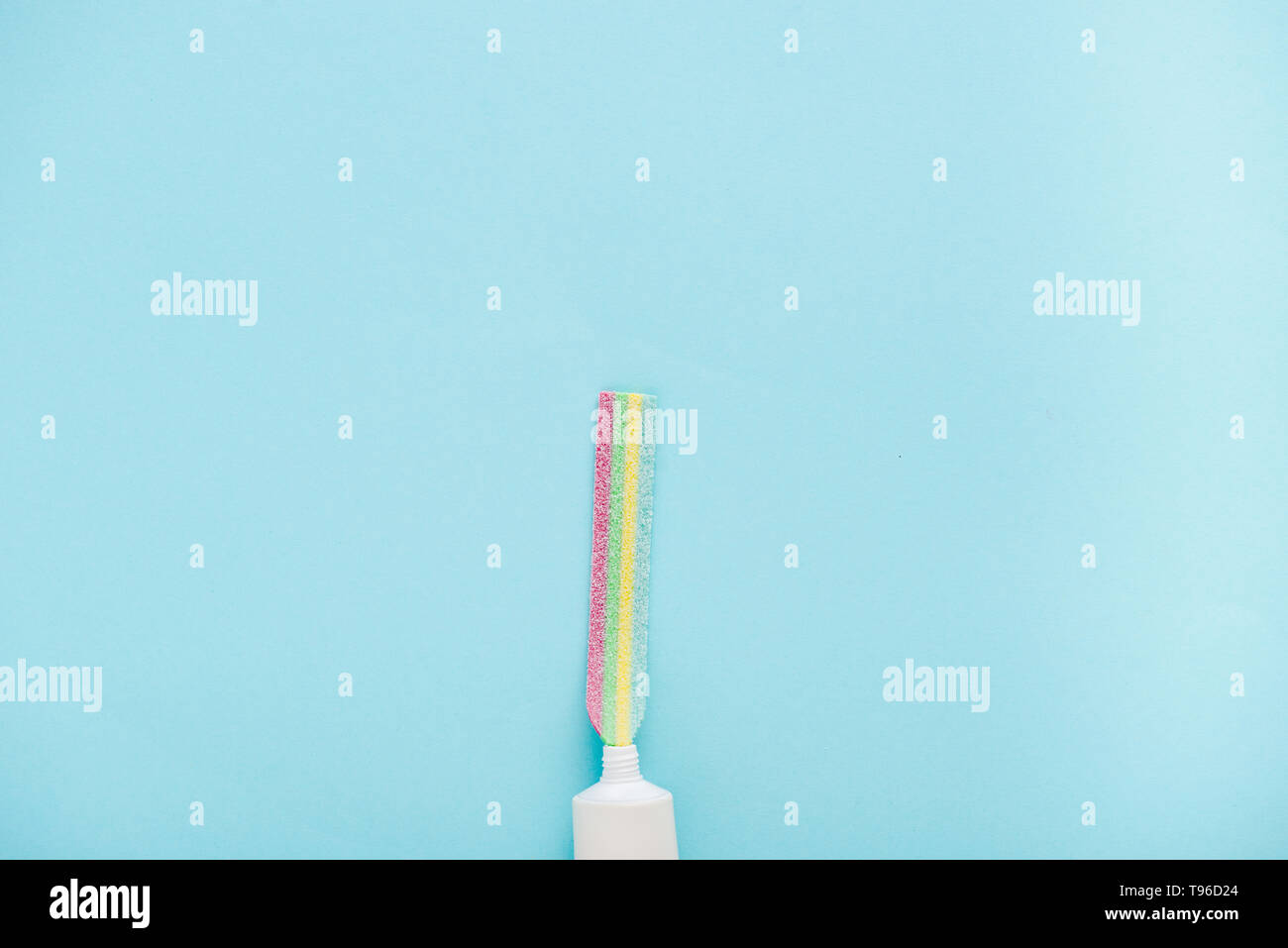 top view of toothpaste tube with chewing colorful candy isolated on ...