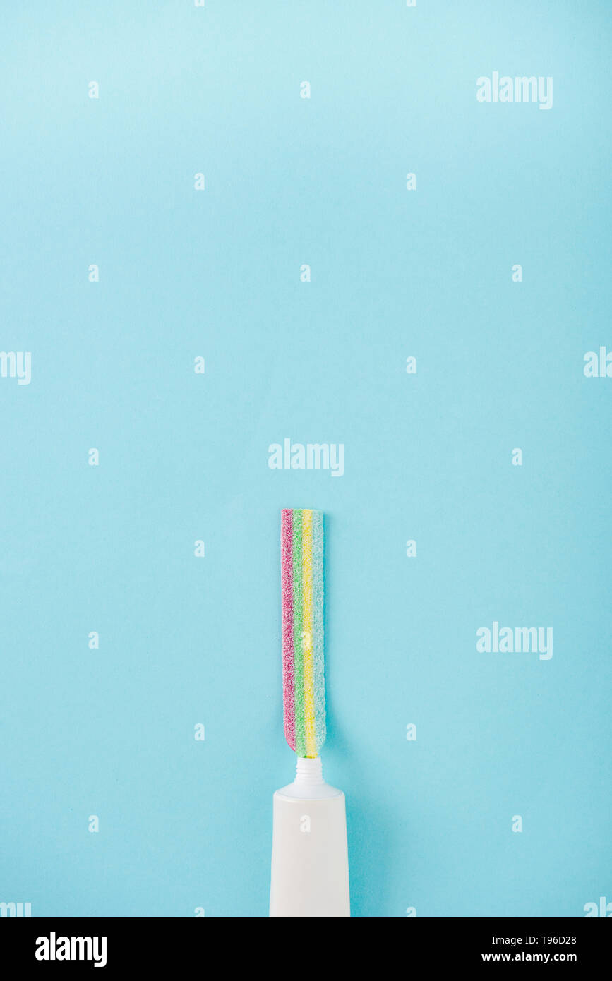 top view of toothpaste tube with chewing colorful candy isolated on ...