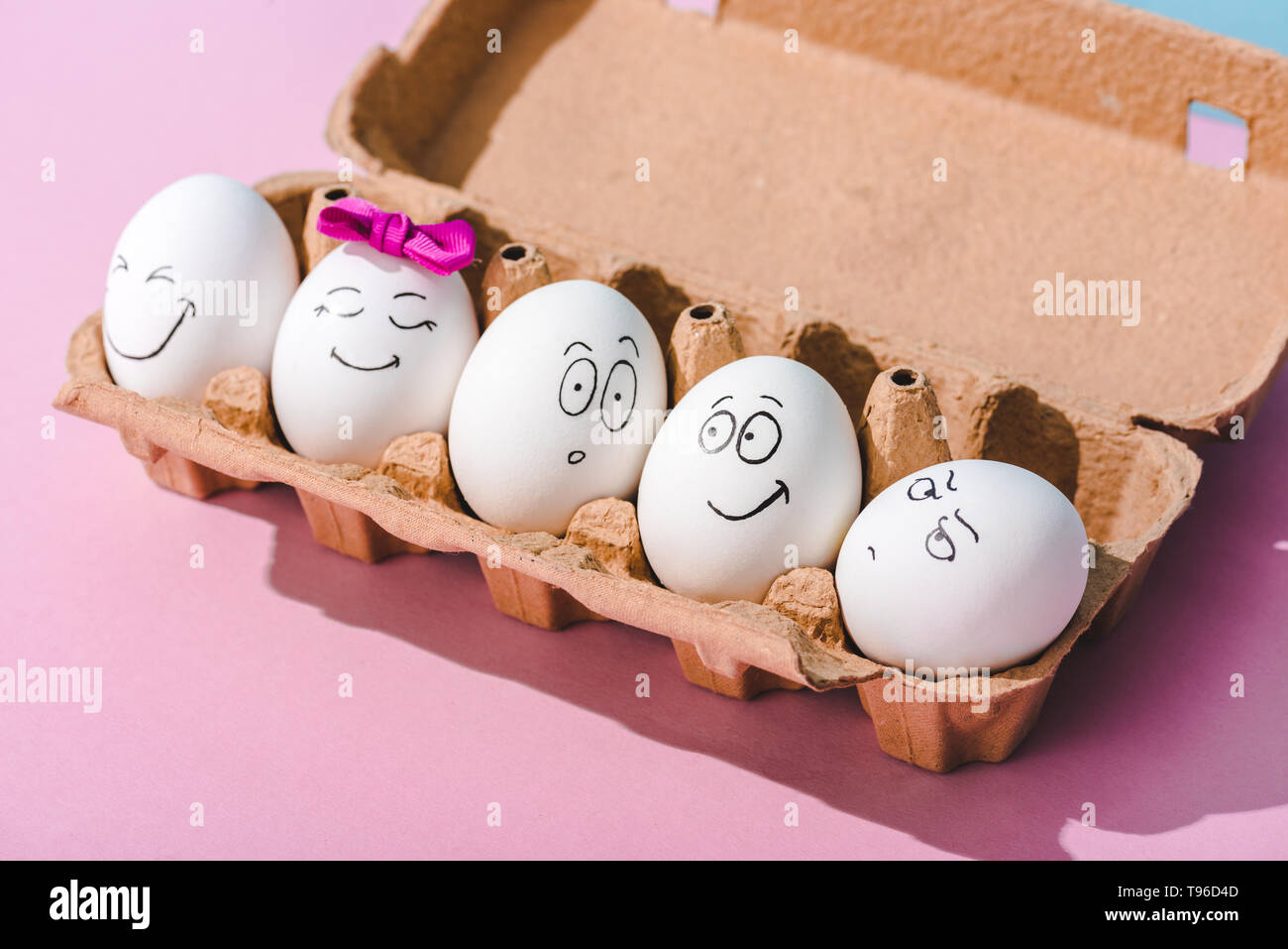eggs with different face expressions in egg carton on pink Stock Photo ...