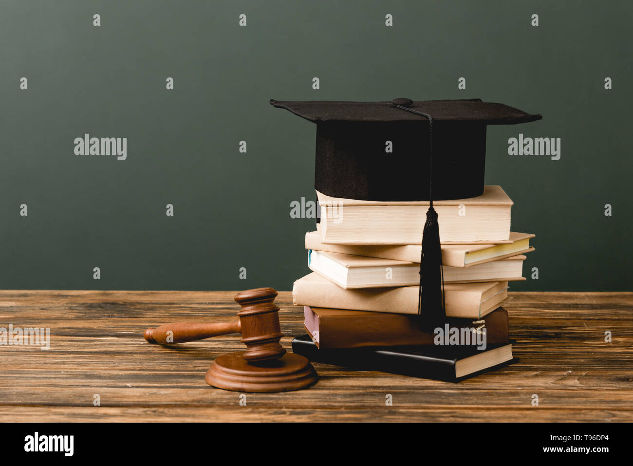 stack of books, academic cap and gavel on wooden surface isolated on ...