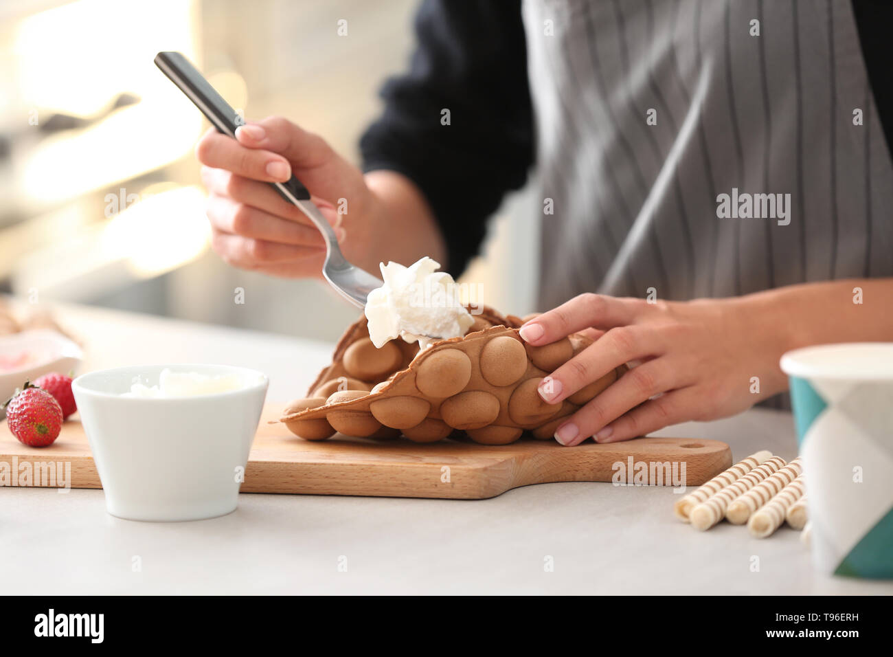 Woman preparing sweet bubble waffles in kitchen Stock Photo - Alamy