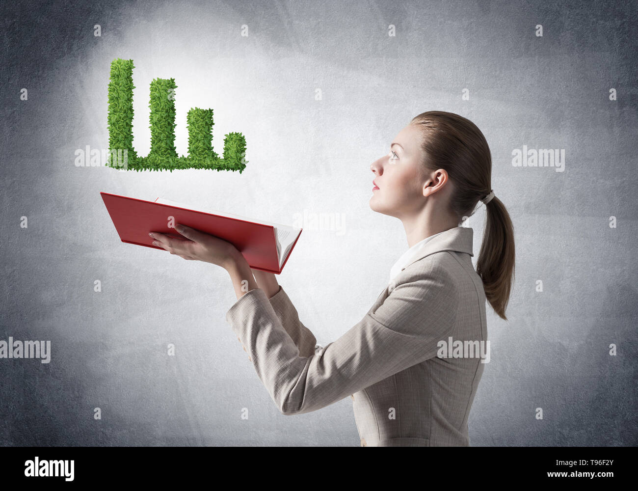 Woman showing green plant in shape of graph Stock Photo - Alamy